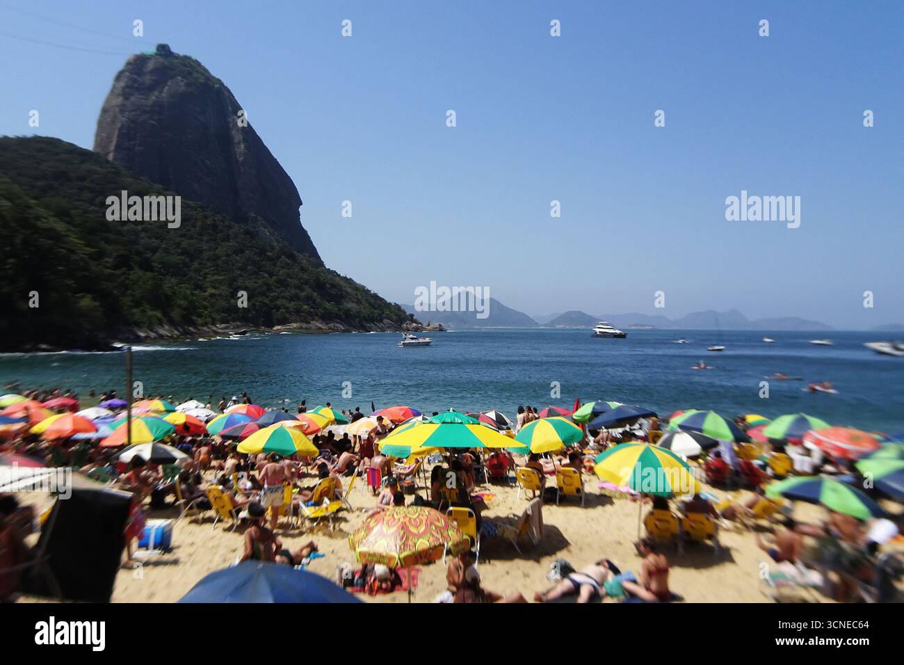 Beachgoers enjoy the sunny and warm weather at Praia Vermelha beach in ...