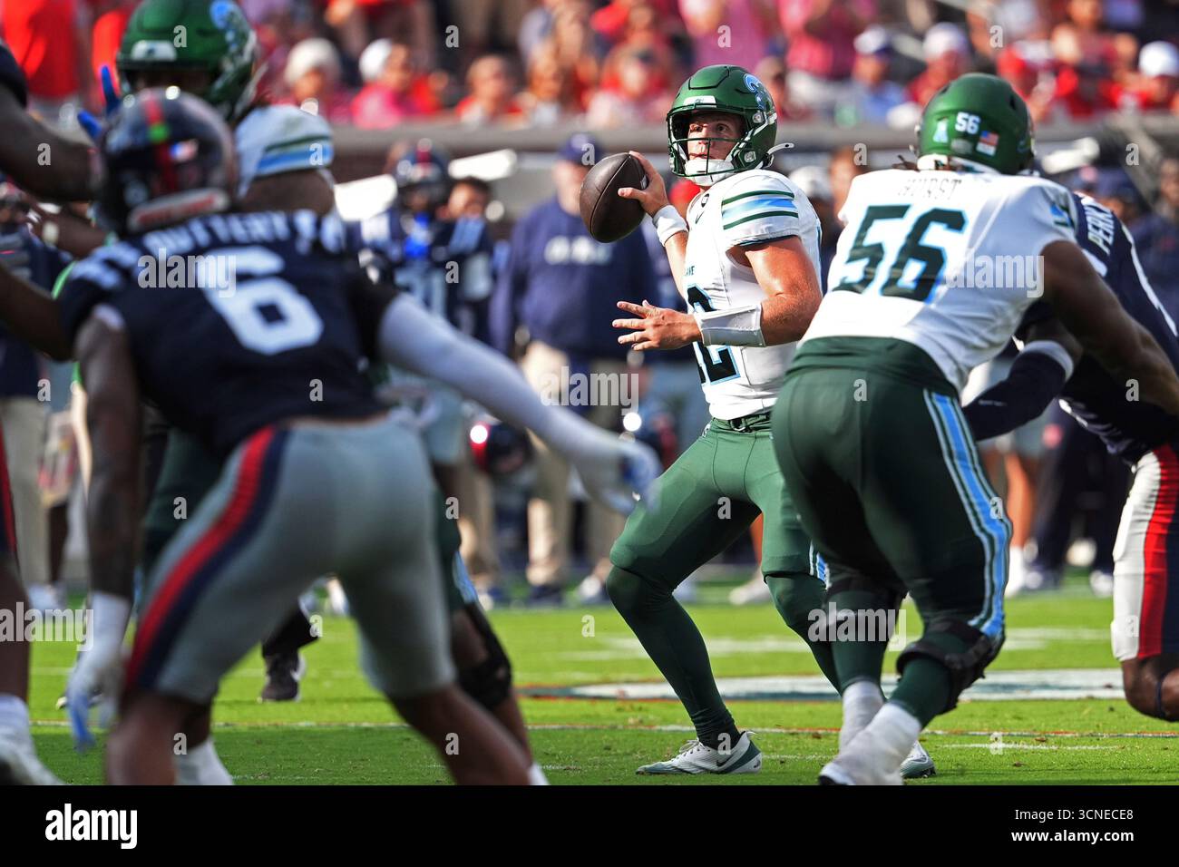 Tulane quarterback Jake Retzlaff (12) passes while offensive lineman ...