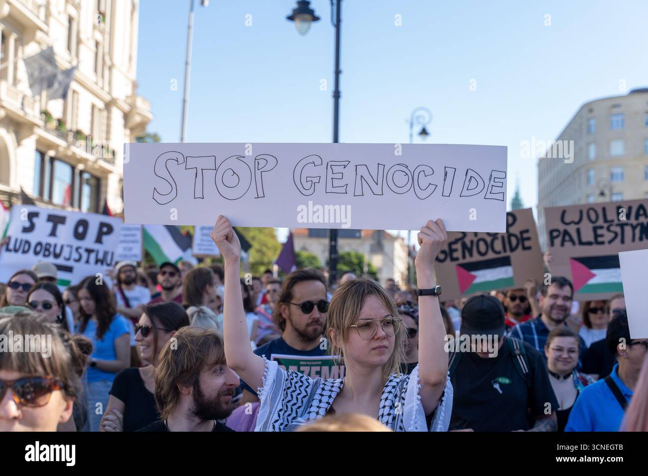 A protester holds a placard saying "STOP GENOCIDE" during the rally ...