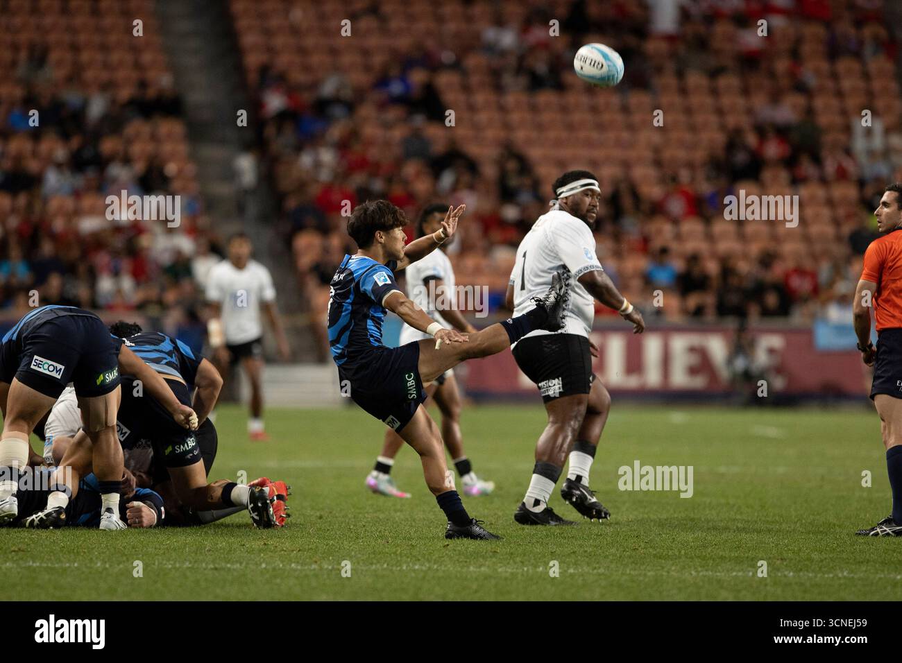 Japan's Shinobu Fujiwara, center, kicks the ball against Fiji's Eroni Mawi during the Pacific ...