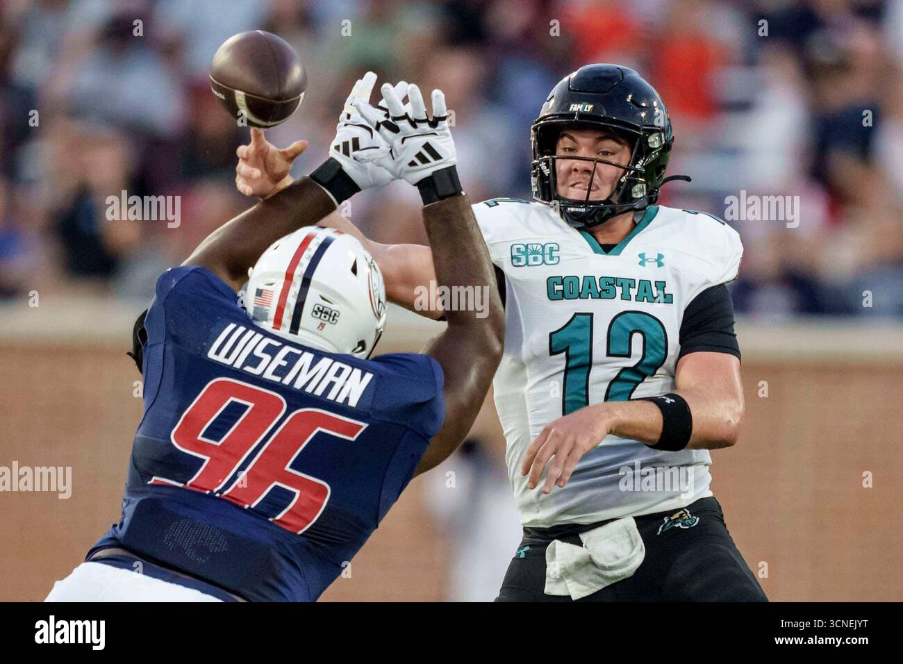 Coastal Carolina quarterback Tad Hudson (12) throws around the hands of ...