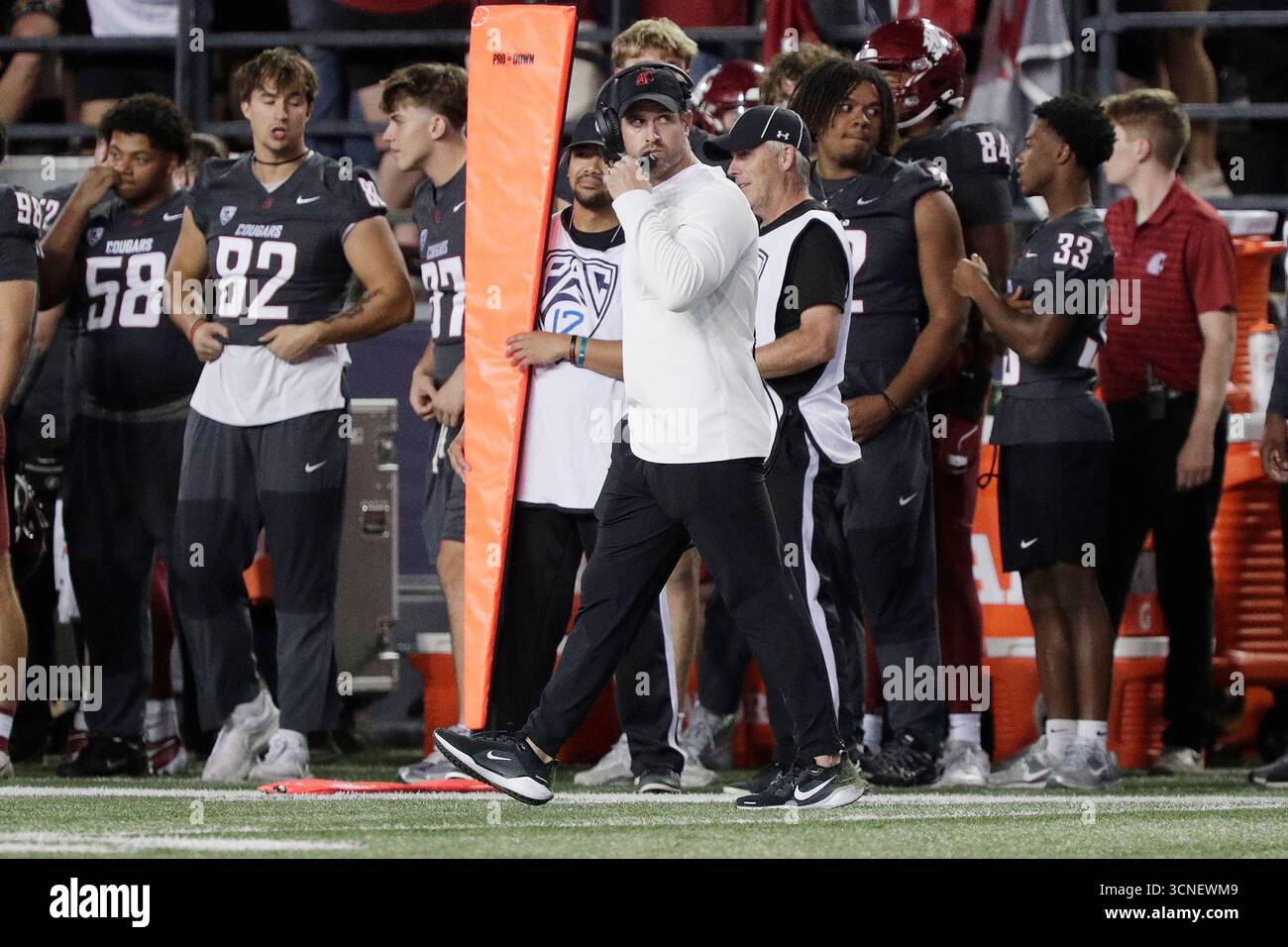 Washington State head coach Jimmy Rogers, center, walks on the field ...