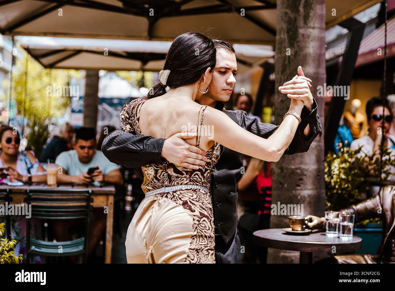 A couple performs an elegant tango on a small café stage in Ciudad ...
