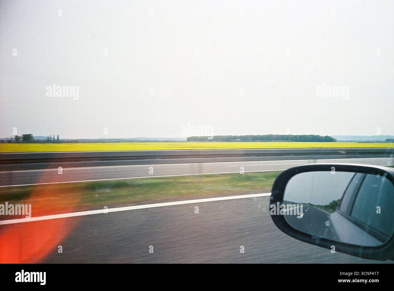 Analog archive photo of farmland landscape seen from a moving car. Side ...
