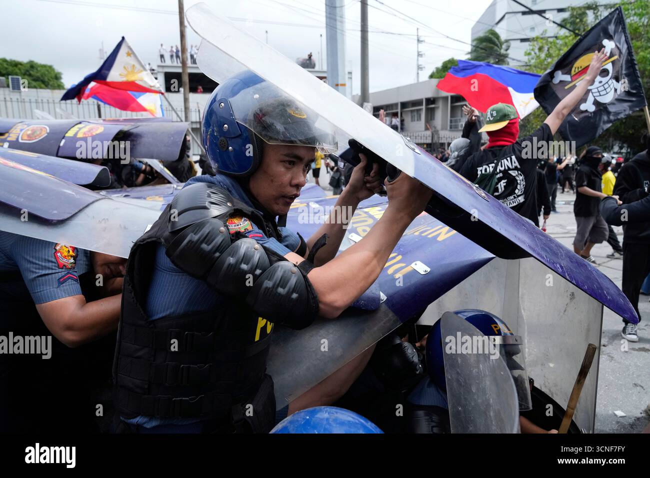 A policeman uses his shield following clashes with protesters as they ...
