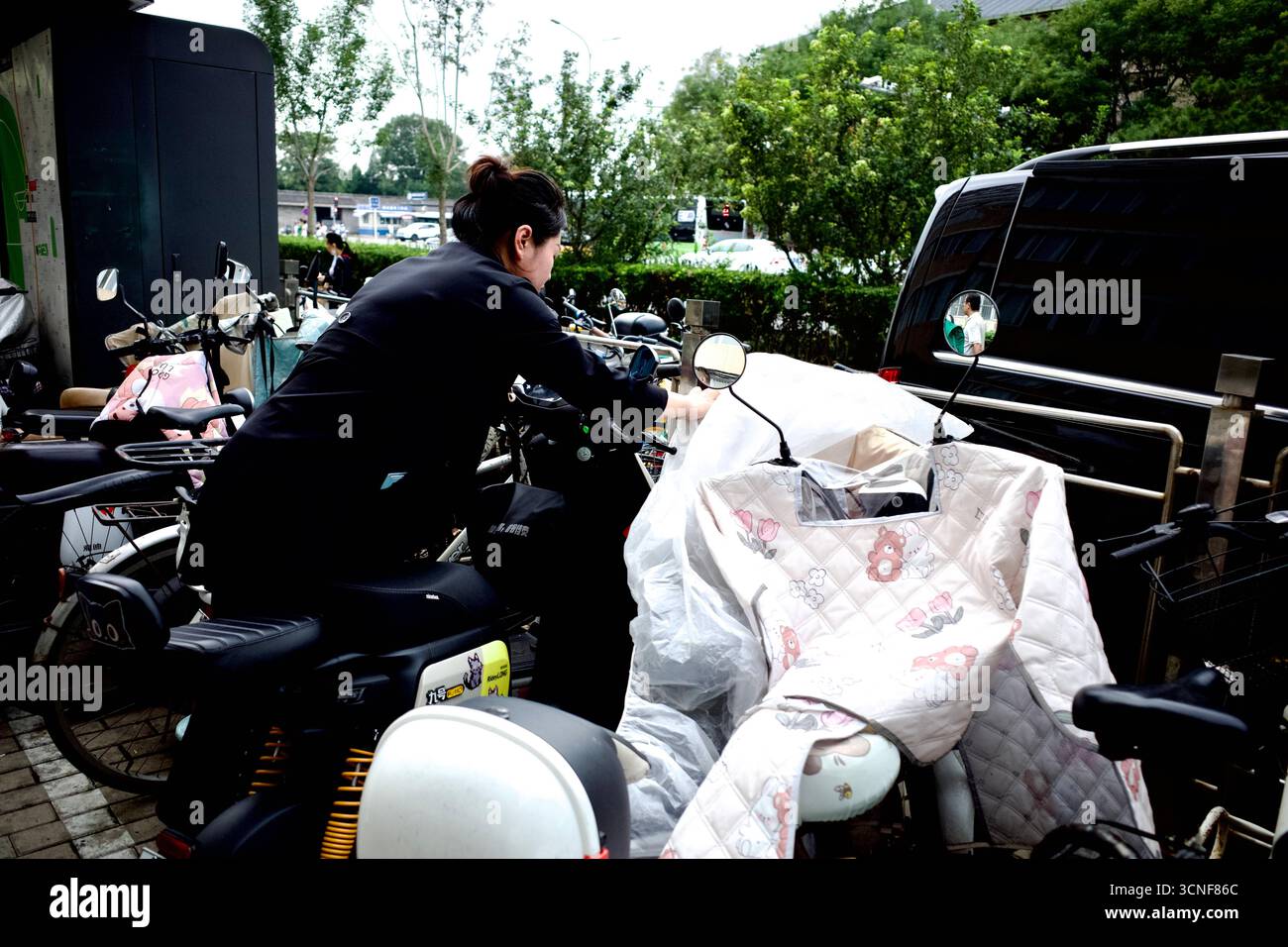 Beijing daily life A general view showing a lady taking athe electric ...