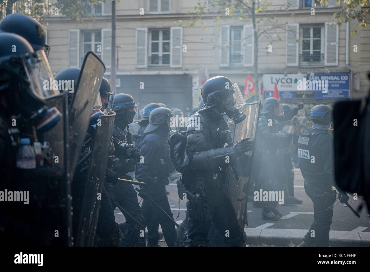 Gendarmes walk in the smoke of the tear gas, wearing masks and anti ...