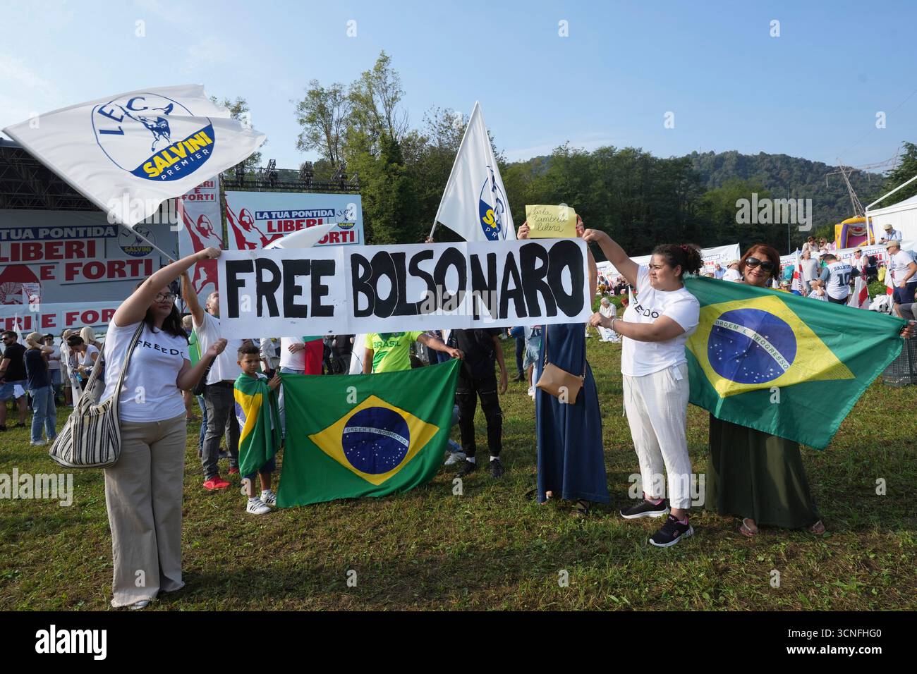 People gather and hold flags and a banner during the League party's ...