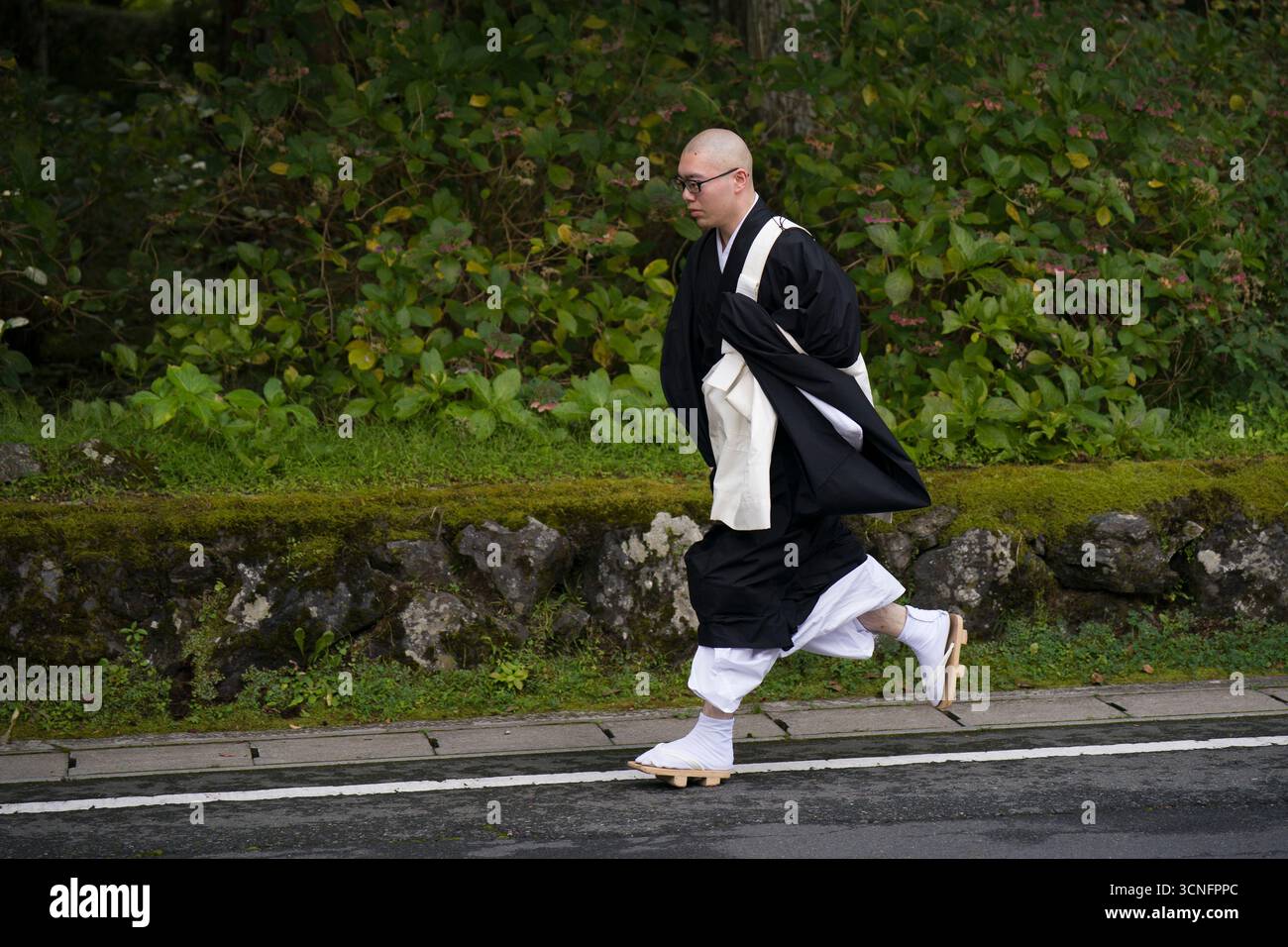A buddhist monk runs down the street in Koyasan, the centre of Shingon ...