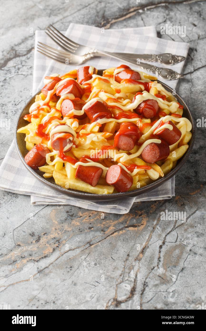 Salchipapa Peruvian Hot Dogs and French Fries with sauces closeup on ...