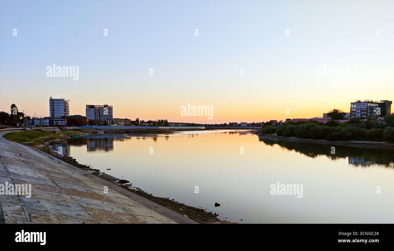 The still water reflects the bright colors of the sky and modern urban ...