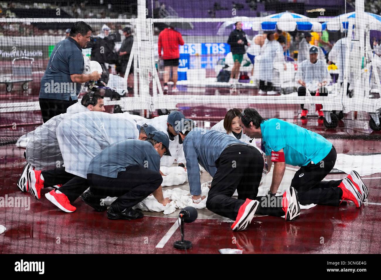 Officials dry the competition ring for the men's discus throw final at ...