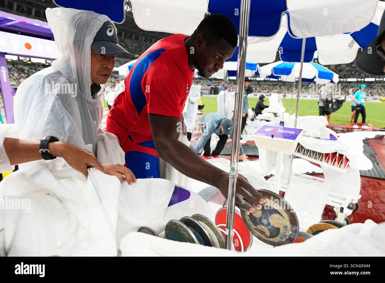 Cuba's Mario Alberto Diaz takes a disk for the men's discus throw final ...