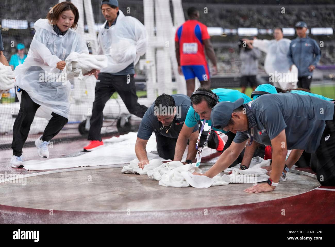 Officials dry the discus circle during the men's discus throw final at ...