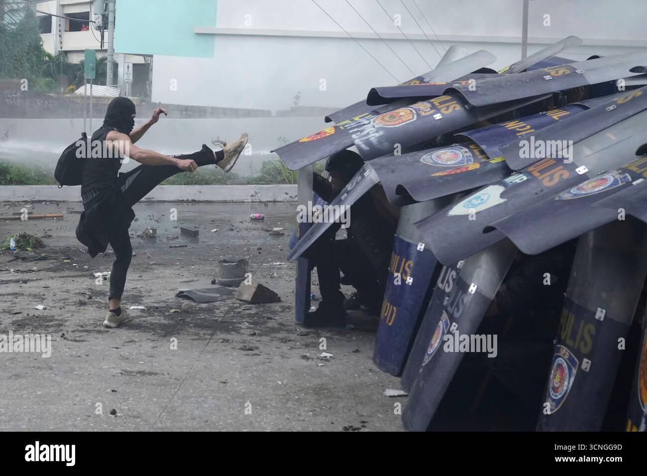 An anti-corruption protester kicks the shield of a policeman during ...