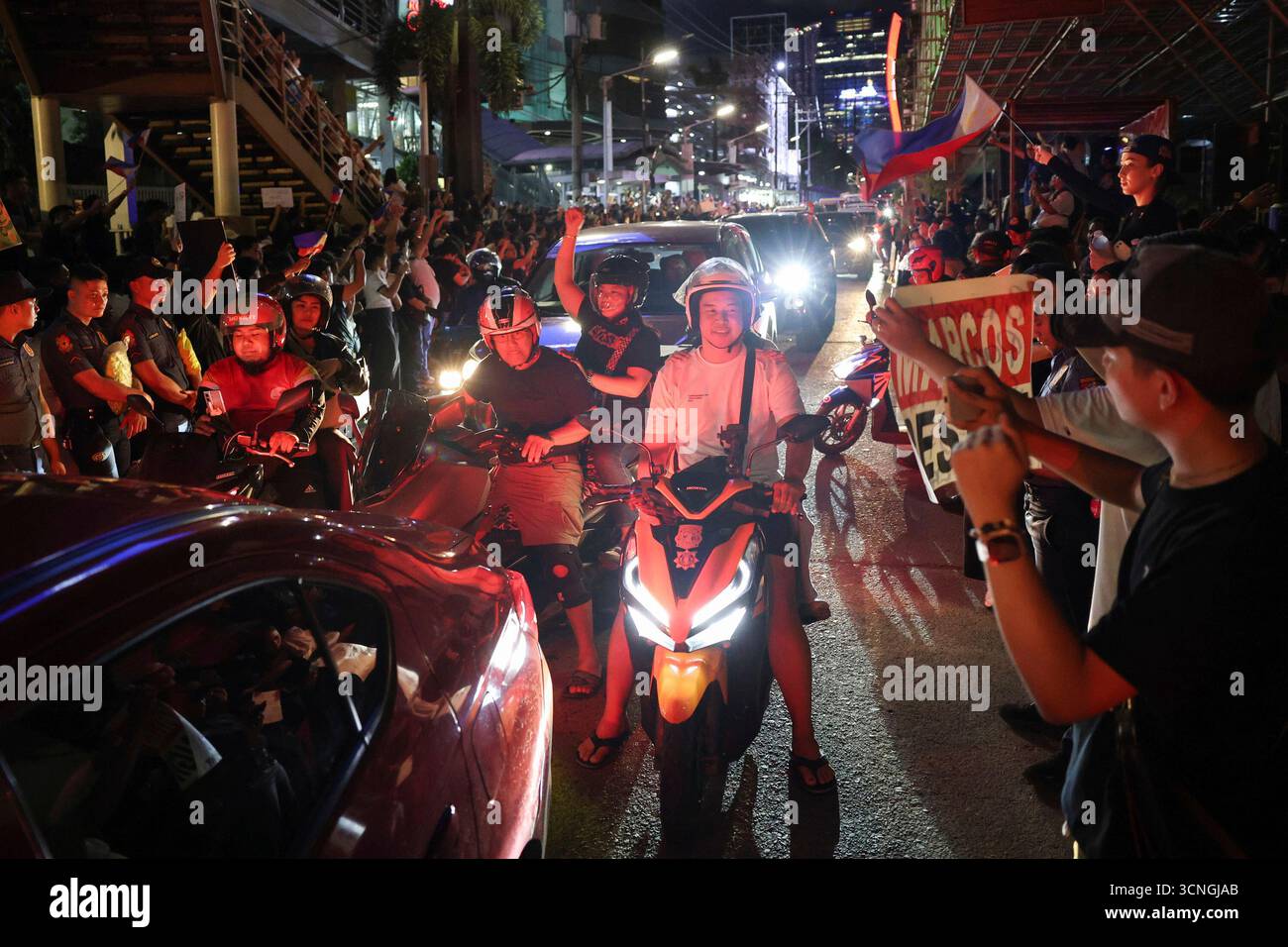 Motorists pass by protesters as they gather at the EDSA People Power ...