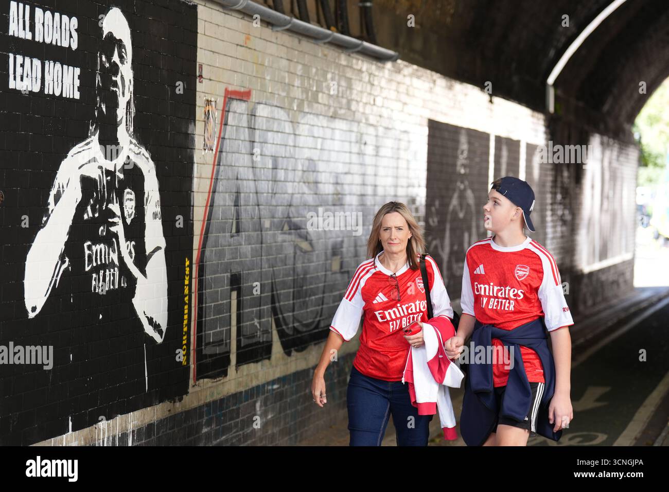 Arsenal fans walk past a mural of Eberechi Eze near Emirates Stadium ...