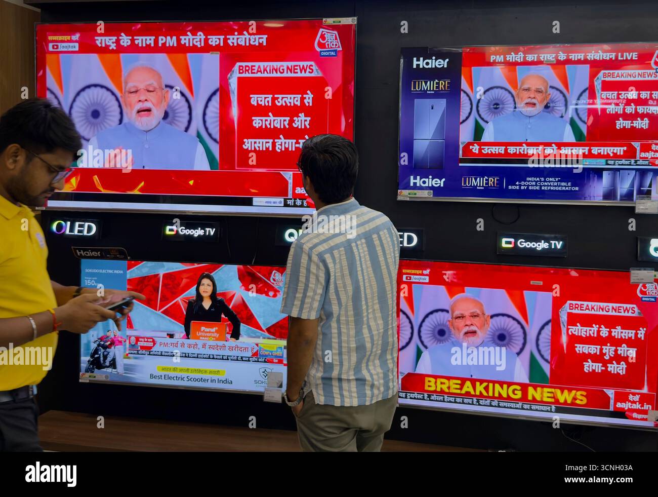 People watch the live telecast of Indian Prime Minister Narendra Modi's ...