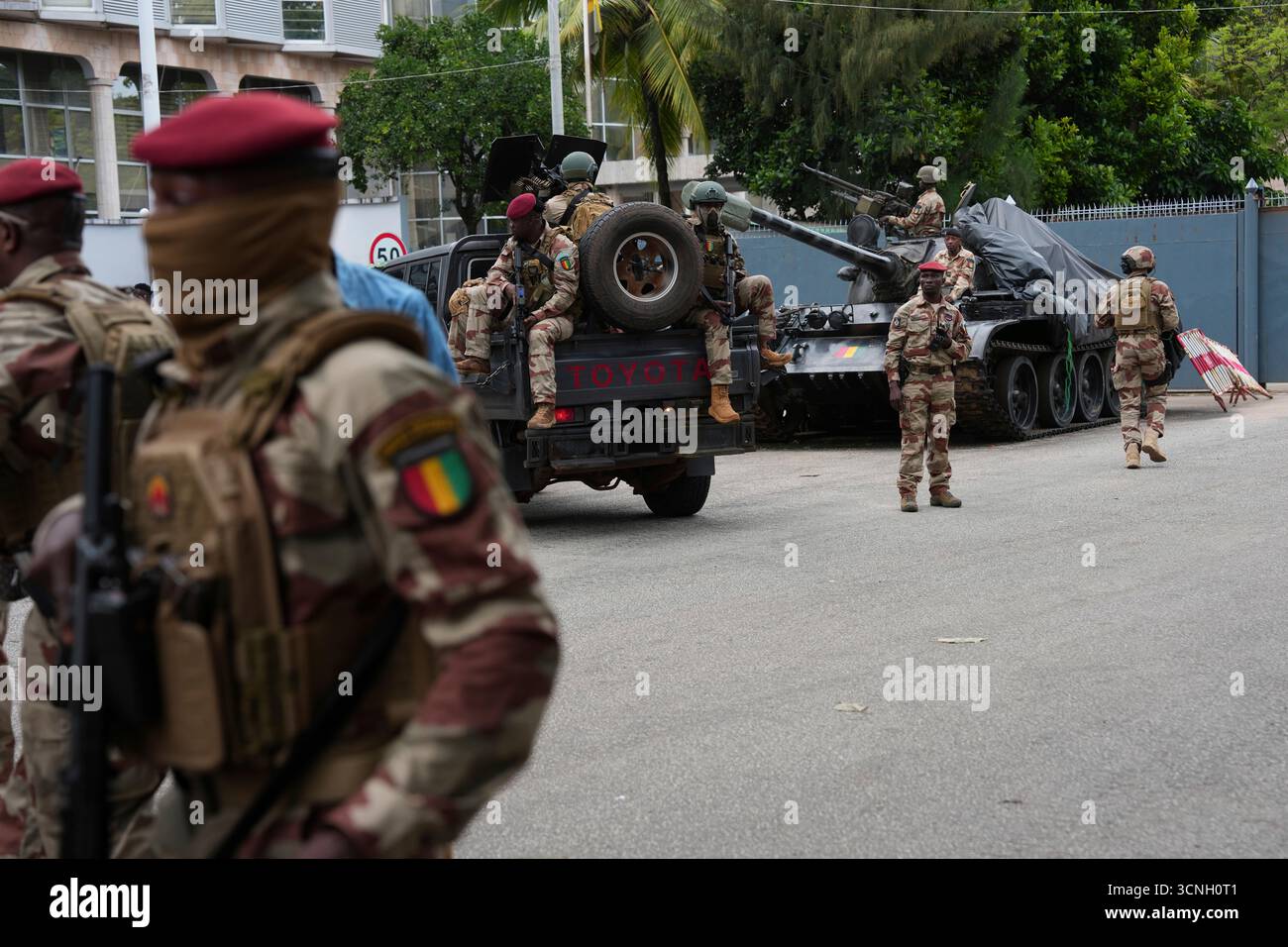 Guinean soldiers stand guard near a polling station where Gen. Mamadi ...