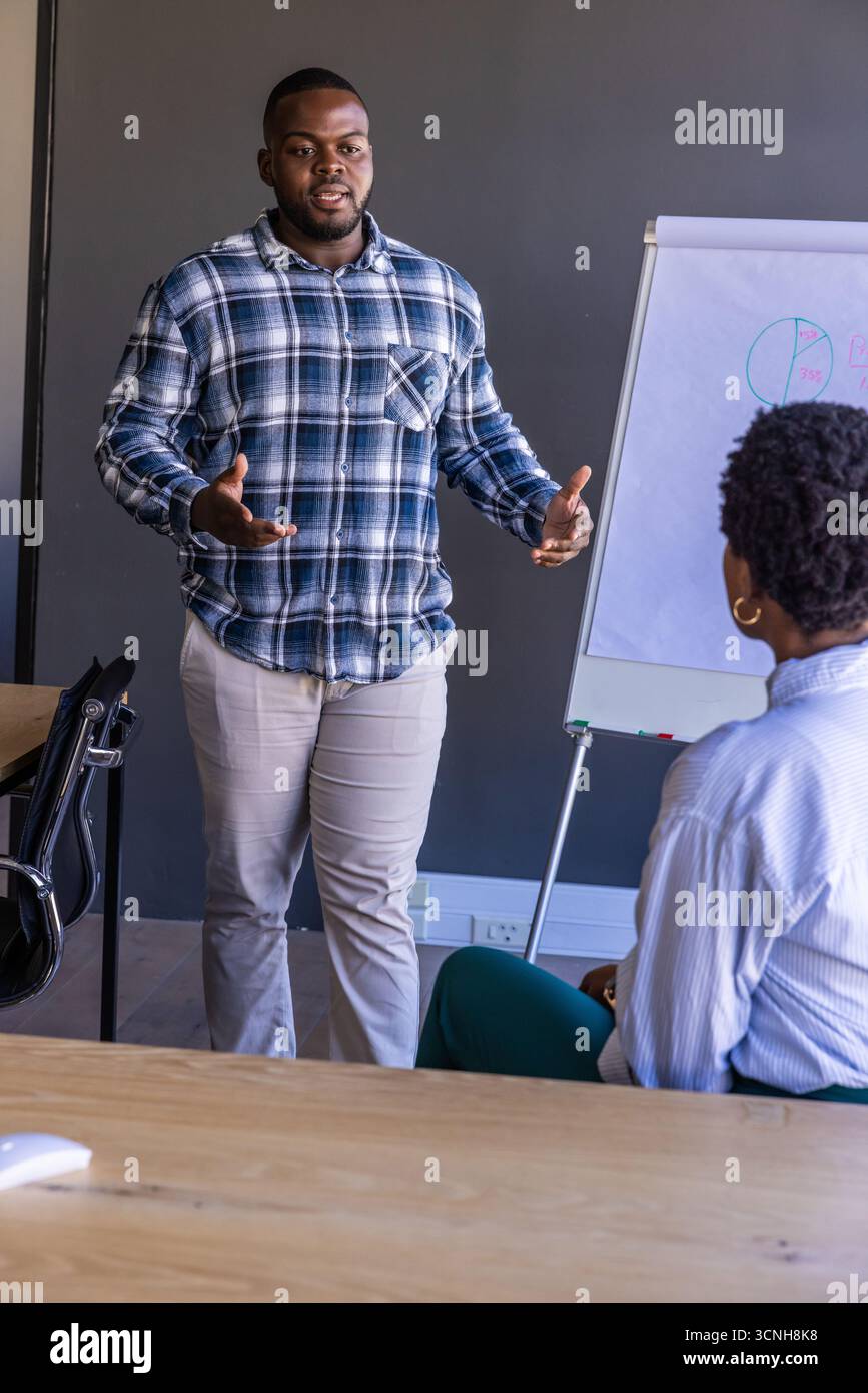 African american colleagues presenting pie chart on tripod easel at ...