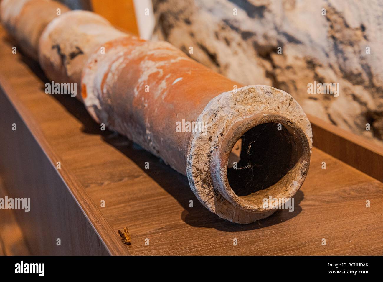 Close up of an old terracotta pipe exhibiting signs of aging, wear, and ...
