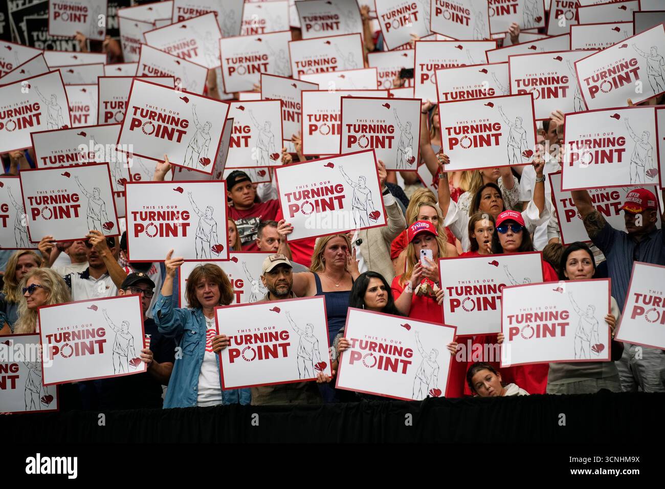 People hold up signs during a memorial for conservative activist ...