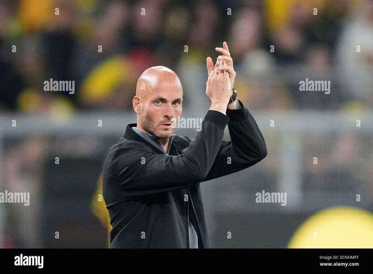 Wolfsburg's head coach Paul Simonis applauds during the German Bundesliga soccer match between ...