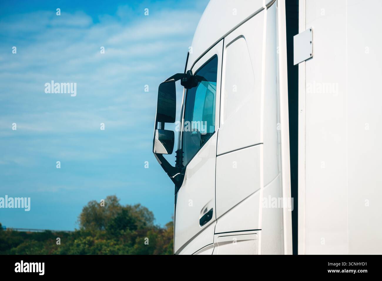 Modern white truck cab closeup under blue sky, symbol of transportation ...