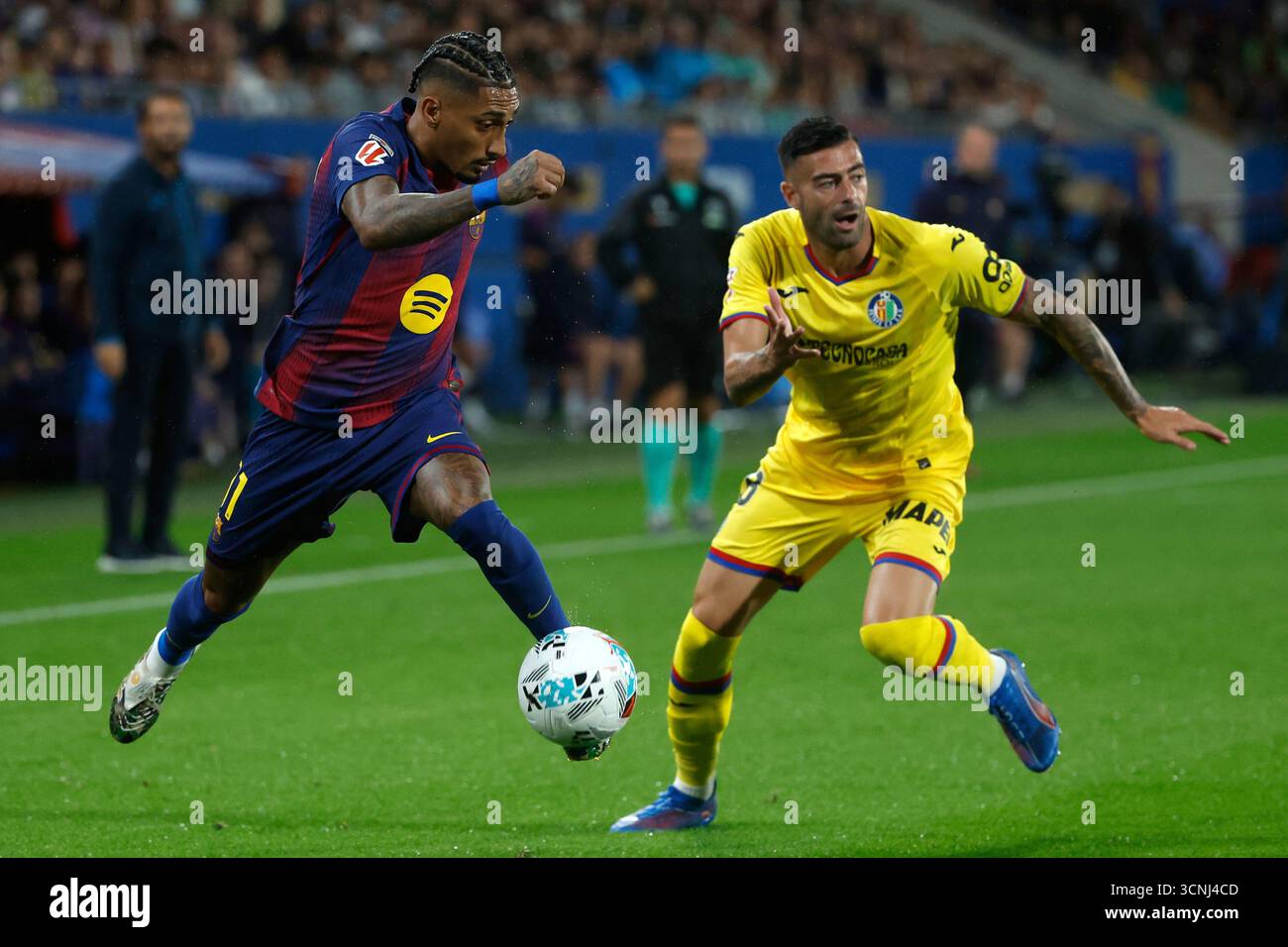 Barcelona's Raphinha fights for the ball against Getafe's Alex Sancris ...