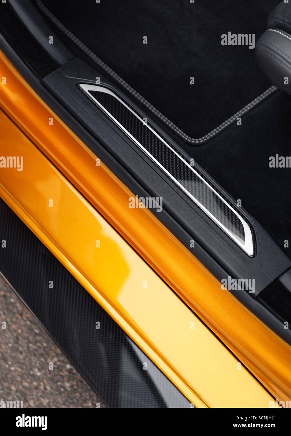 Door sill of amber sportscar. View of parked car showing wide door sill ...