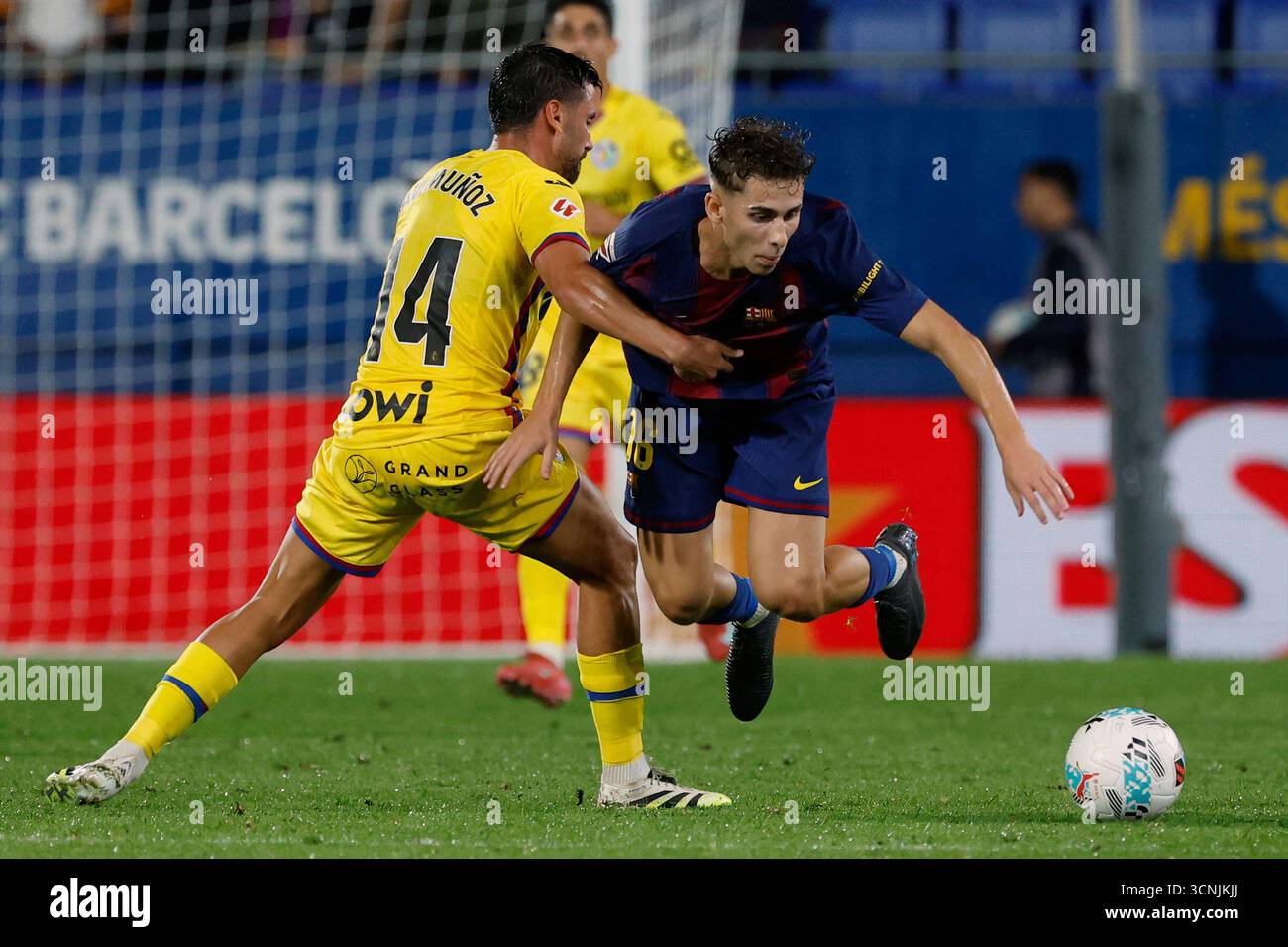 Getafe's Javi Munoz fights for the ball against Barcelona's Fermin ...
