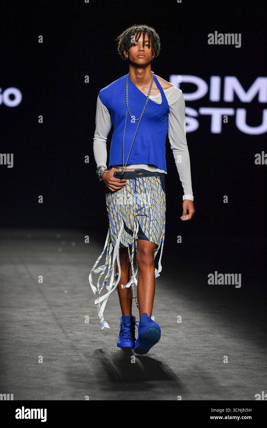 A model walks the runway wearing a design by Dimoni Studio during the ...