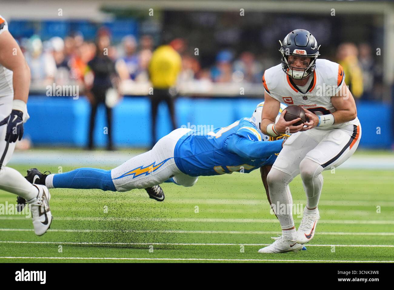 Denver Broncos quarterback Bo Nix (10) evades the tackle from Los ...