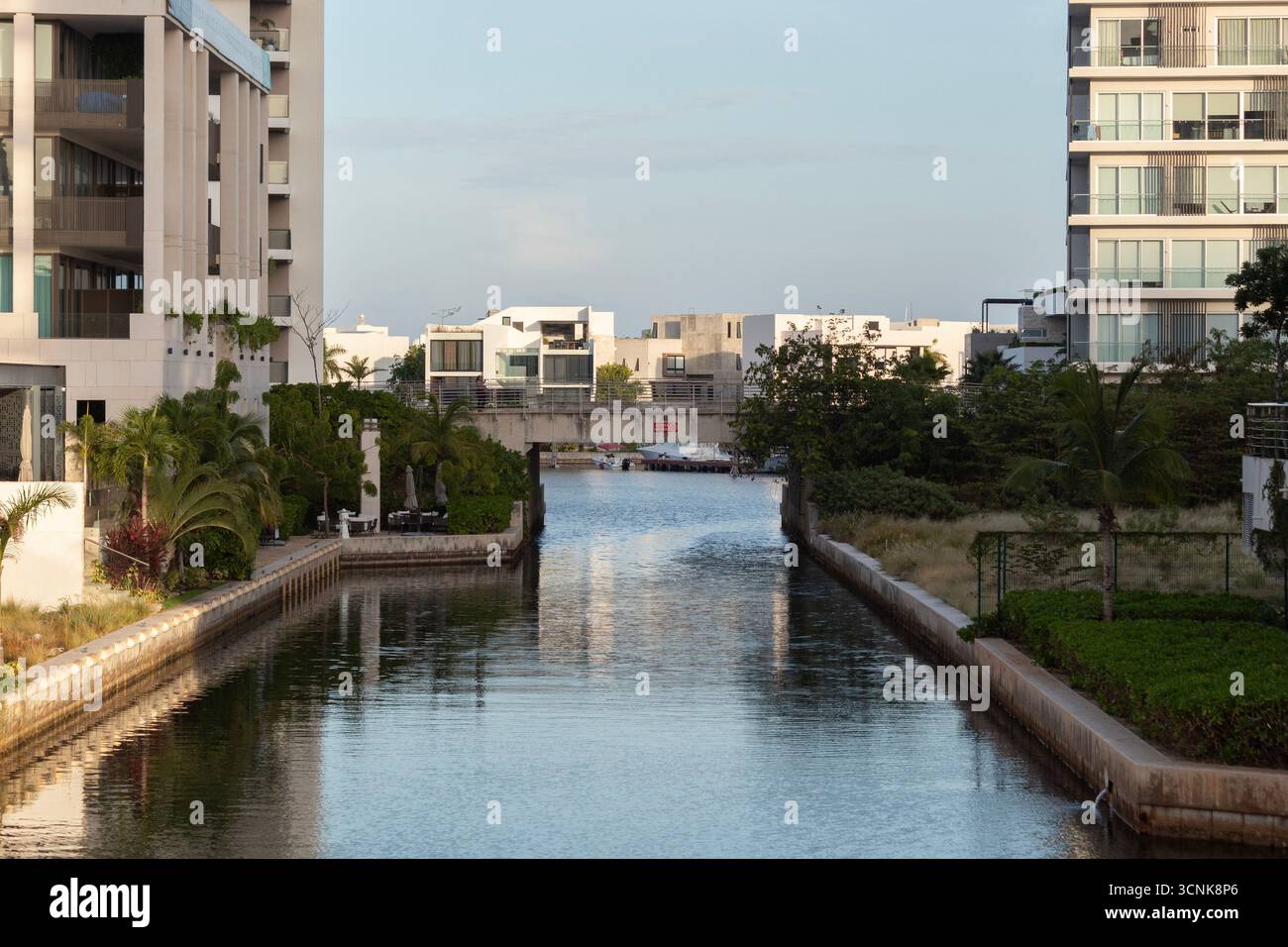 A modern bridge over a small canal in middle of a residential buildings ...