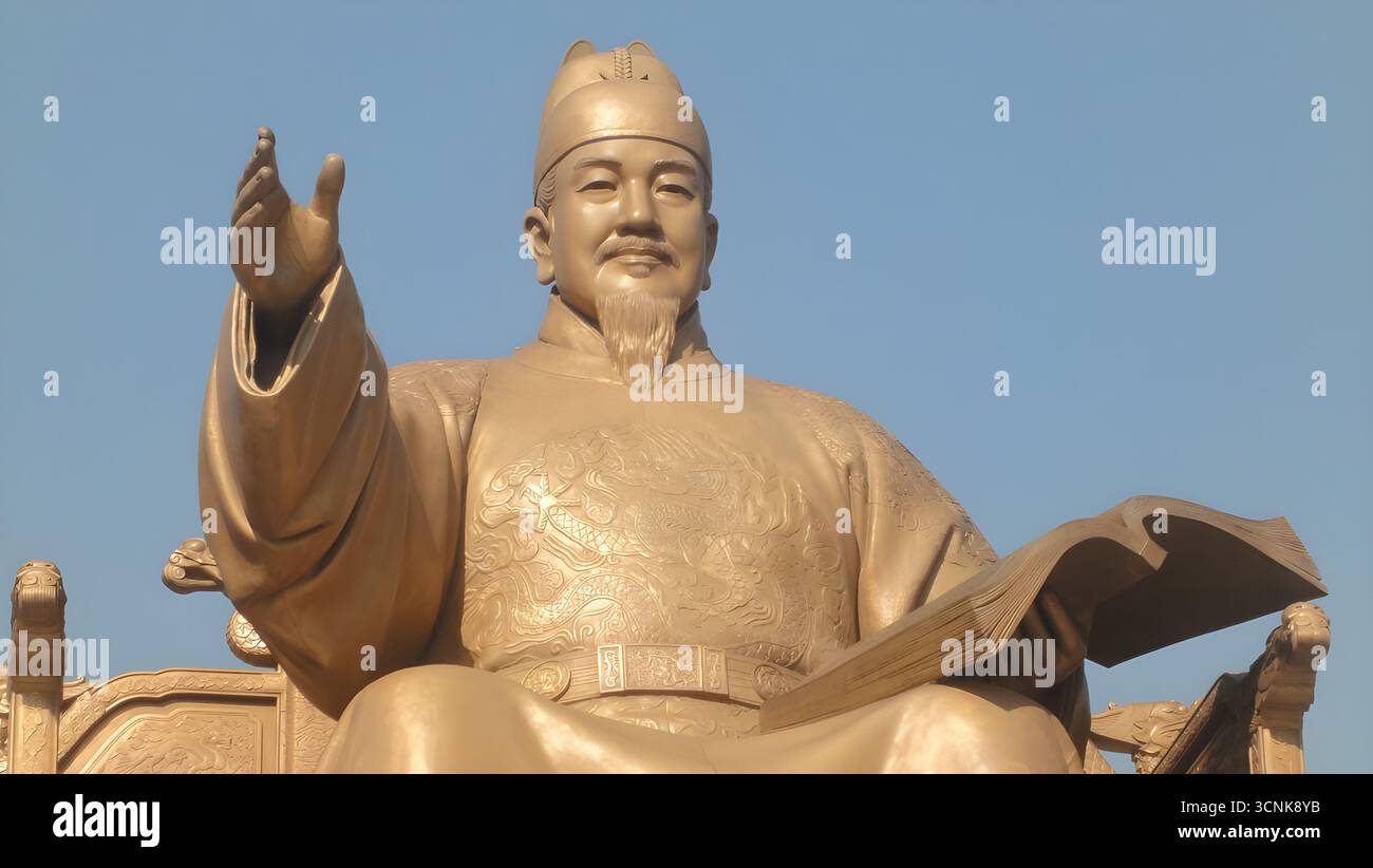 The golden bronze statue of King Sejong the Great, holding a book and ...