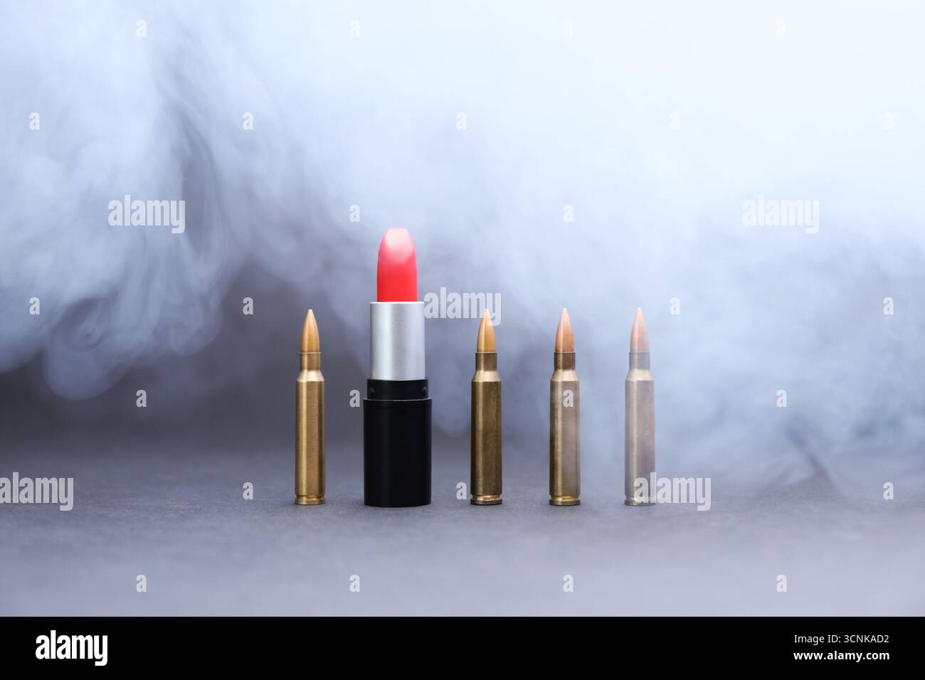Red lipstick among bullets in smoke on grey background Stock Photo - Alamy