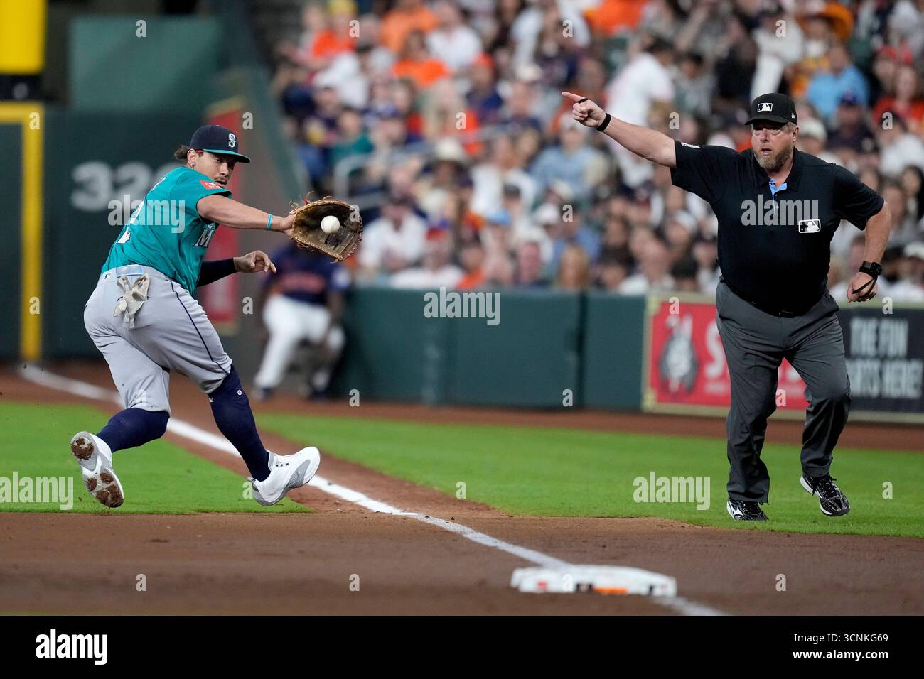 Seattle Mariners first baseman Josh Naylor, left, fields a ground ball ...