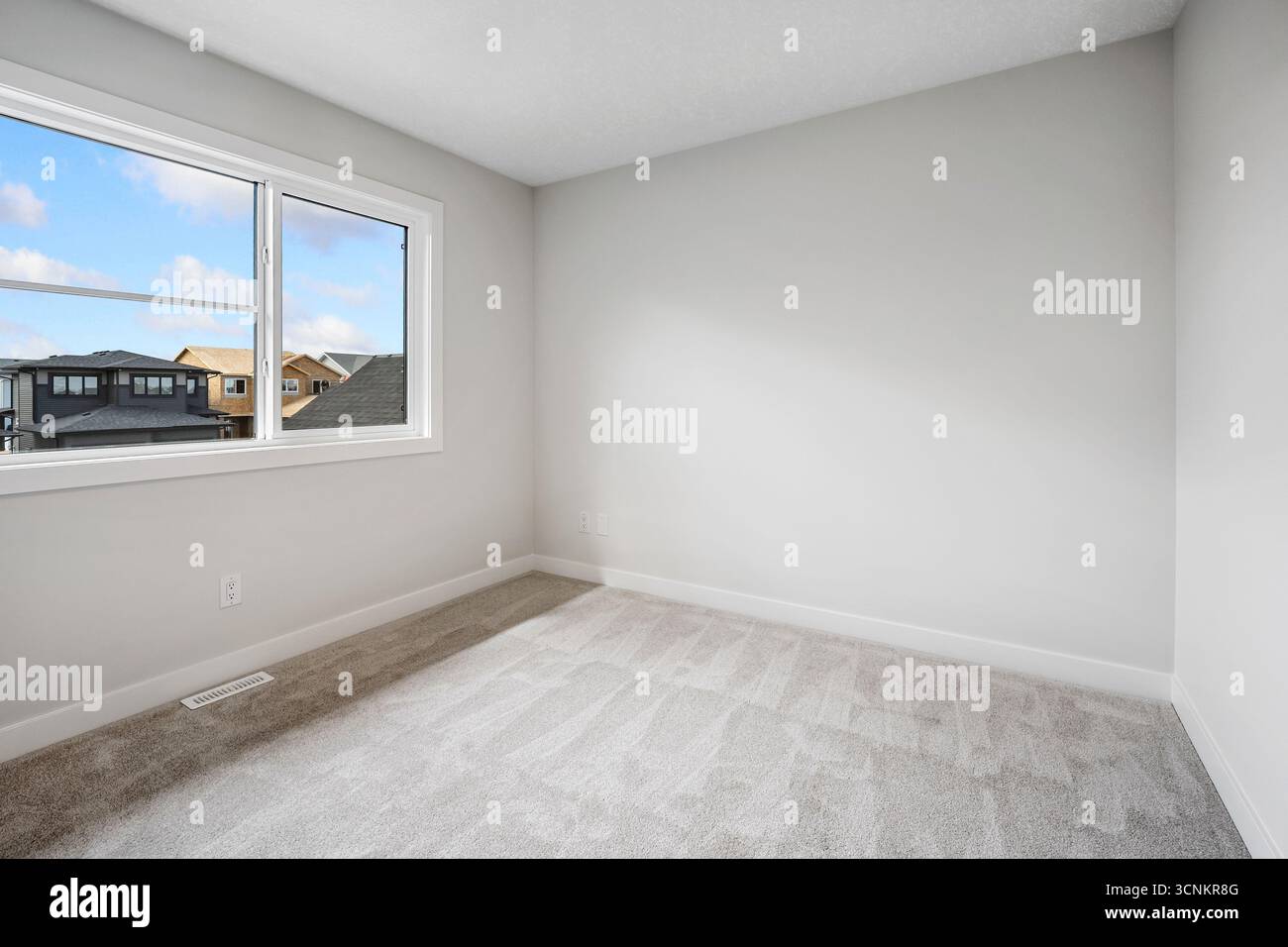 Very clean and empty bedroom with a large window. The room is very ...