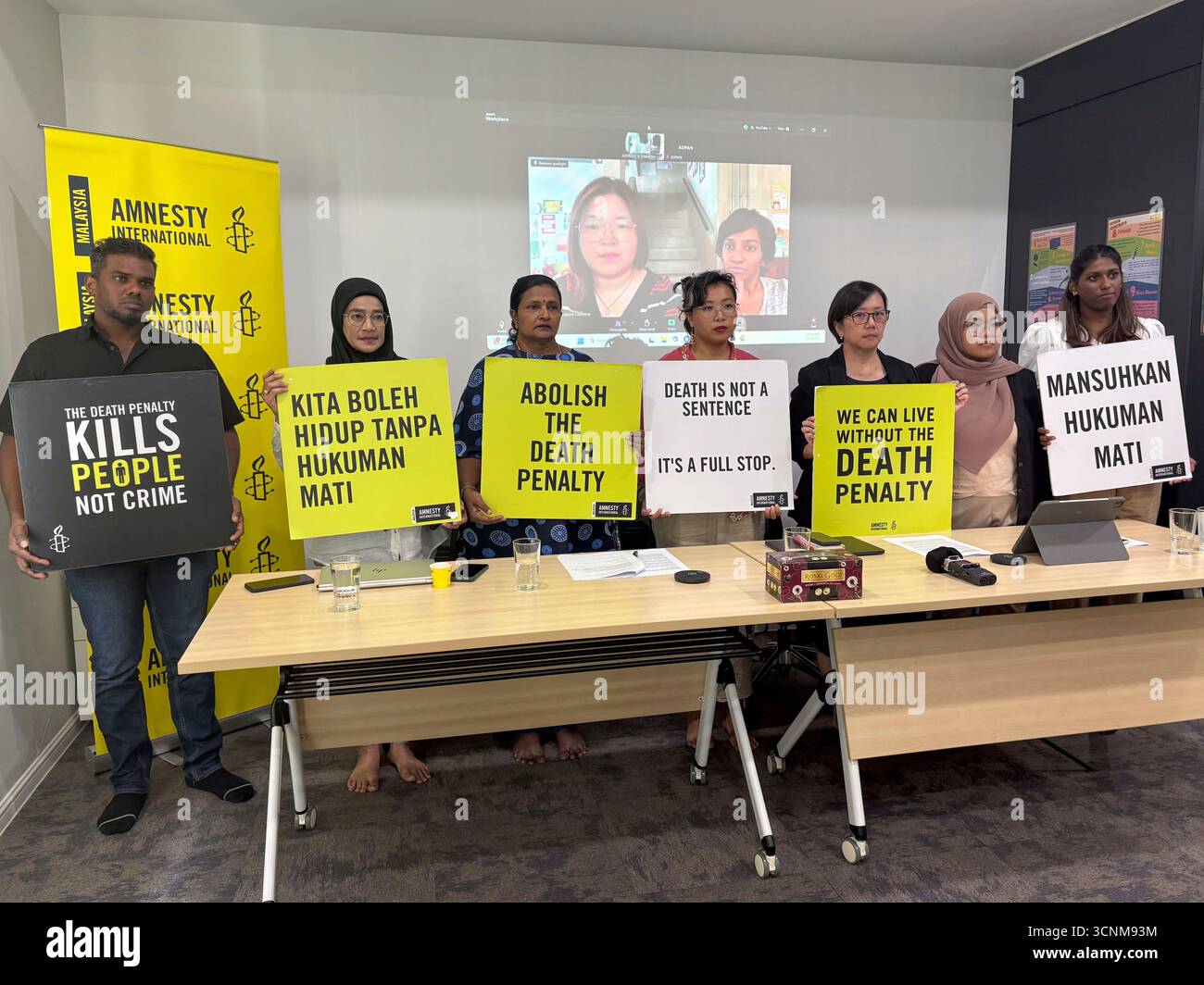 Nicole Fong, forth left, from Amnesty International Malaysia, holds a ...