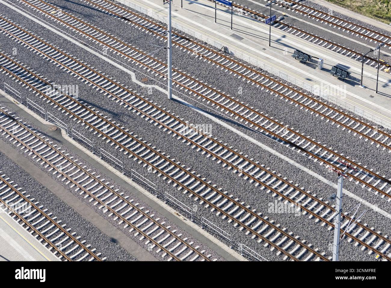 Aerial view of parallel train tracks glinting under the sun, a stark ...