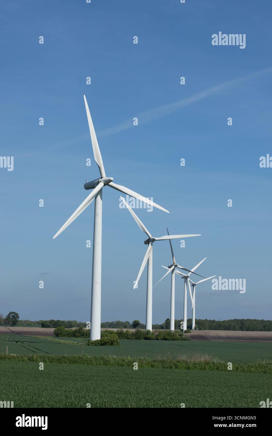 five windmills in a row in green landscape, green wind power vertical ...
