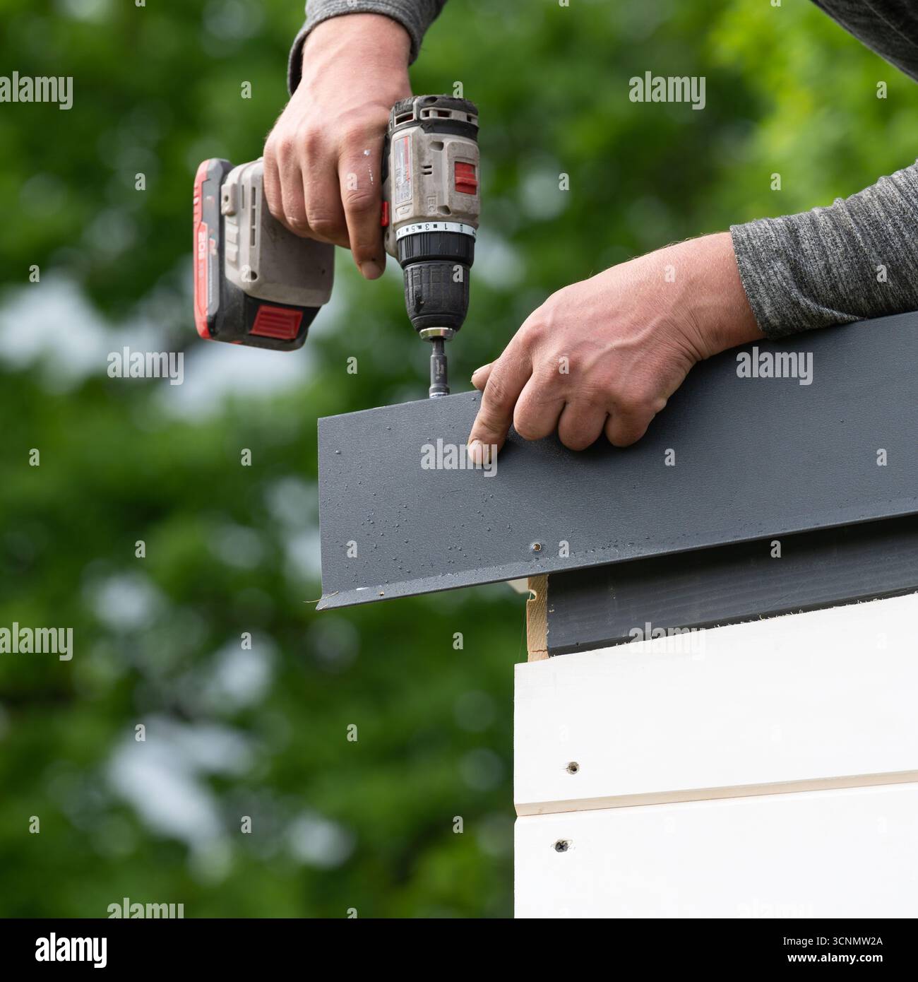 Moments of roof installation using a screwdriver, construction work in ...