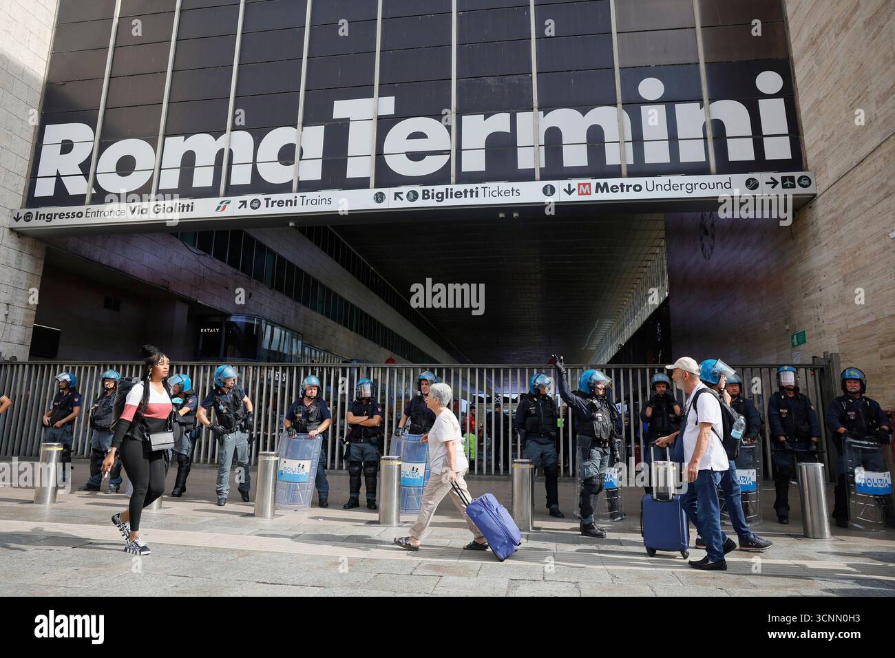 Italian police in riot gear guard a closed off entrance to Termini ...