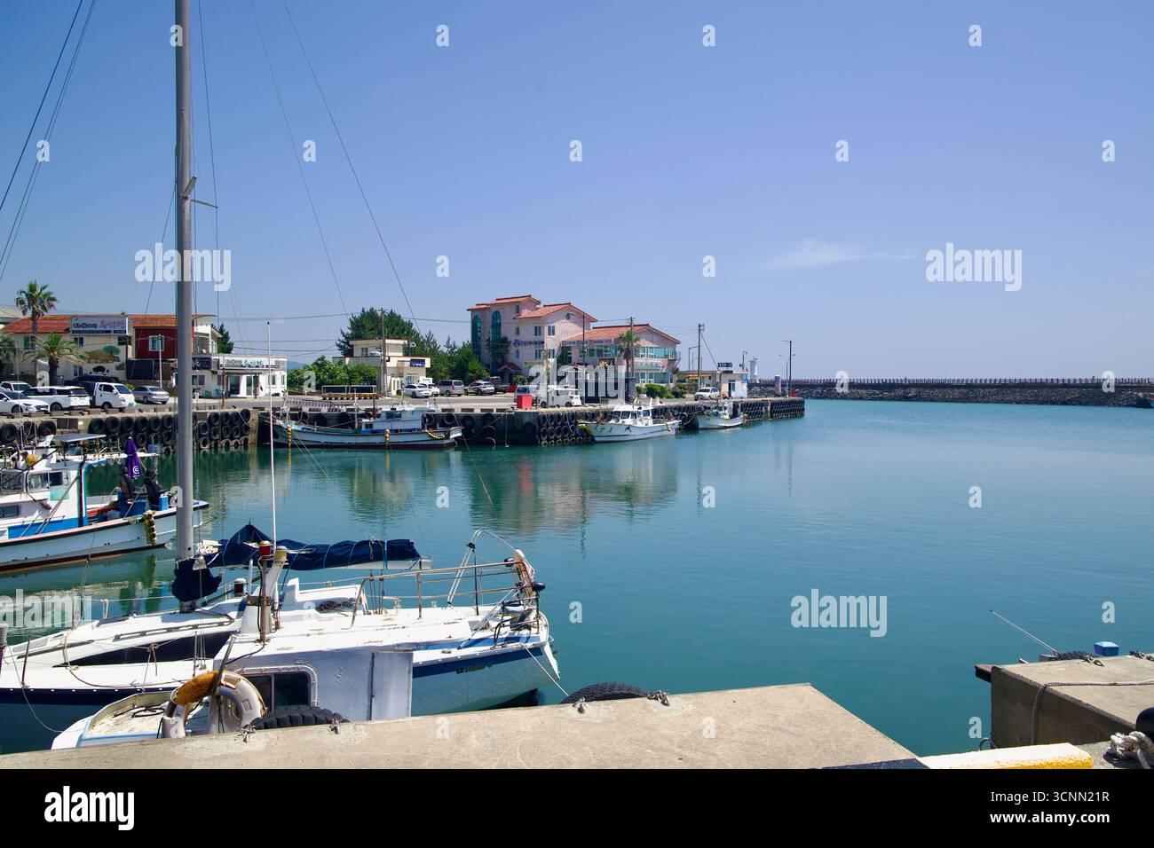 The inner basin of Pyoseon Port lies calm under clear skies, with ...