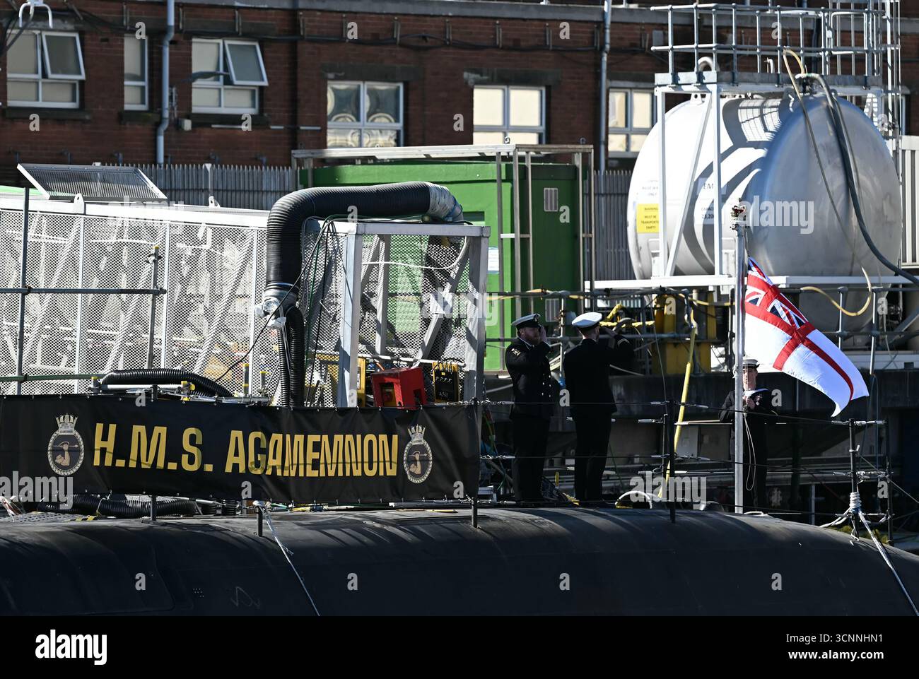 Officers raise a white ensign during a Commissioning Ceremony for HMS ...