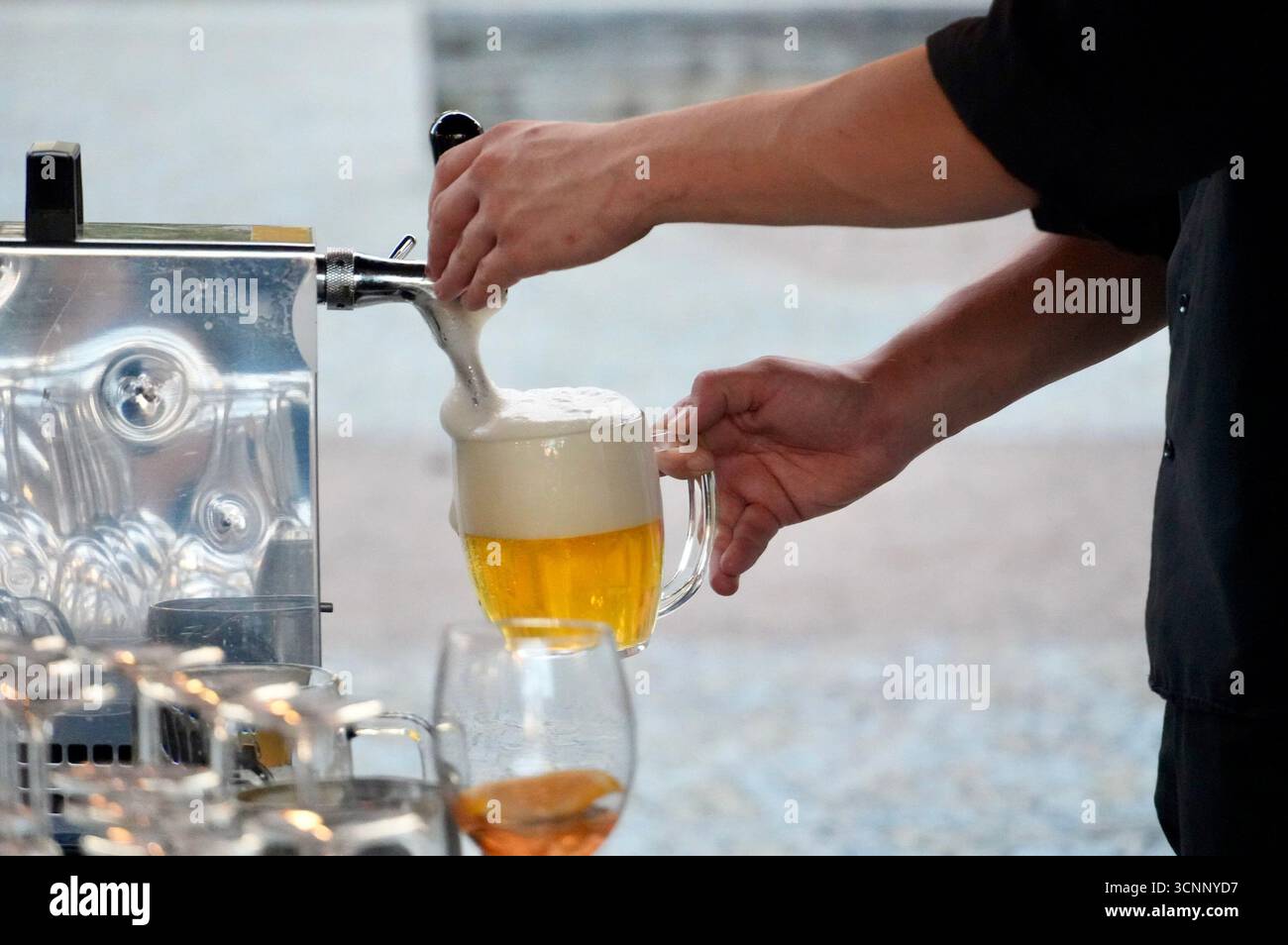 Barman pouring beer into a glass from the coffee machine, close-up ...