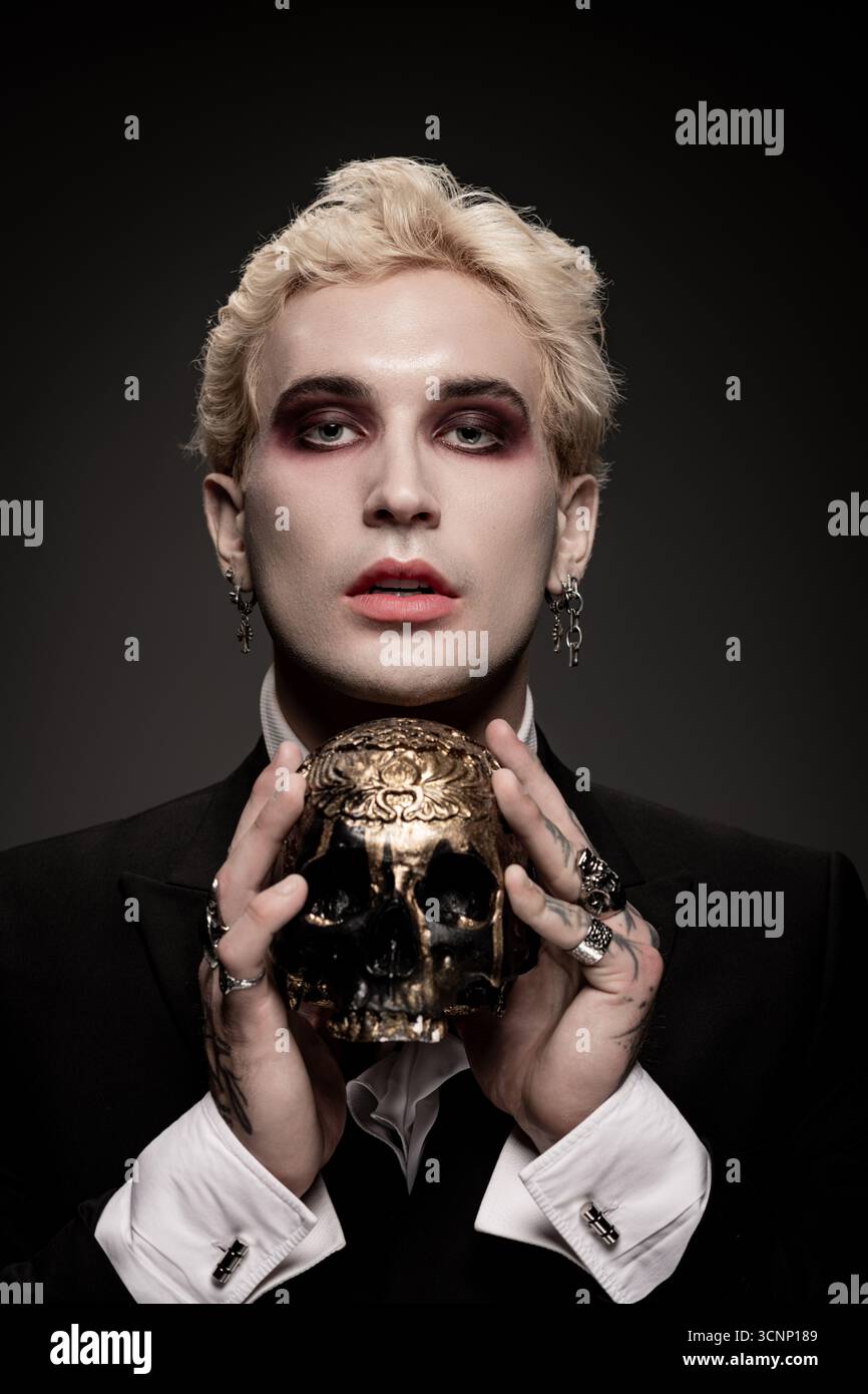 This young man impresses in a Halloween costume, holding a golden skull ...