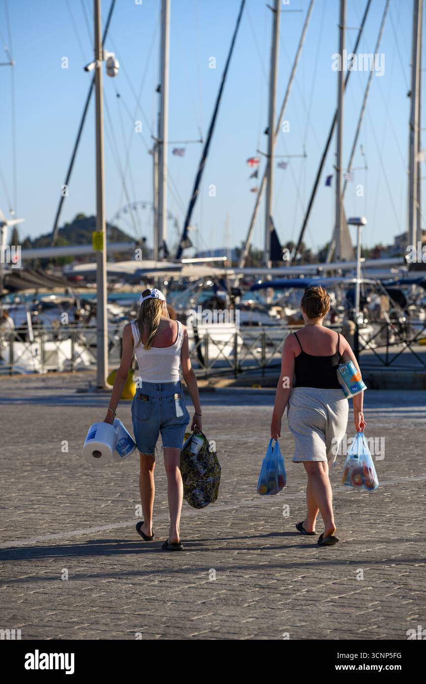 two female crew members taking provisions back to their boat on the ...