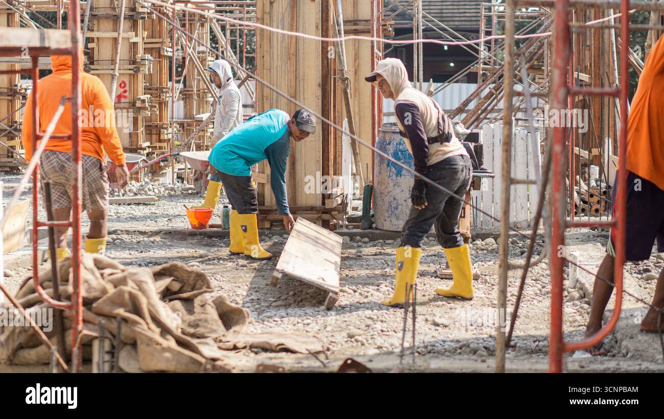 Construction workers dismantle column formwork after concrete curing ...