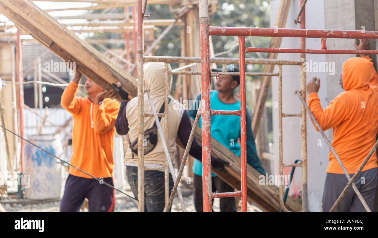 Construction workers dismantle column formwork after concrete curing ...